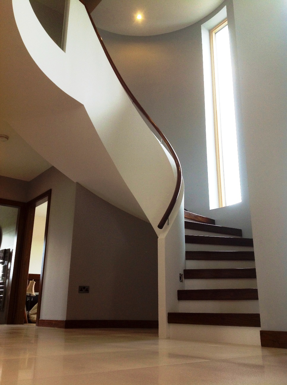 Curved concrete stairs - Cladded with walnut treads and inset curved ...